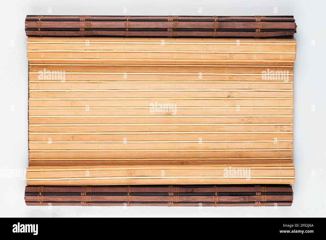 Dark and light bamboo rug with curled edges. View from above. Place for ...