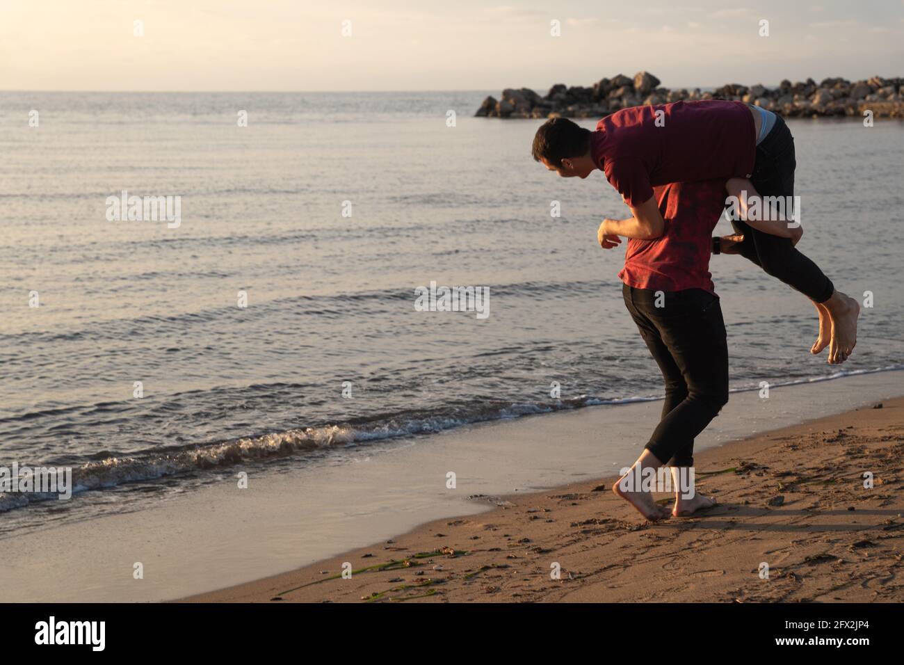 Man carrying another man. Two friends. One is carrying the other. They ...