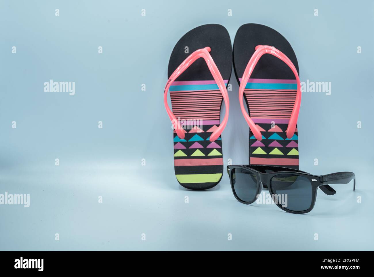 summer sunglasses and flip flops composition with copy space and blue ...