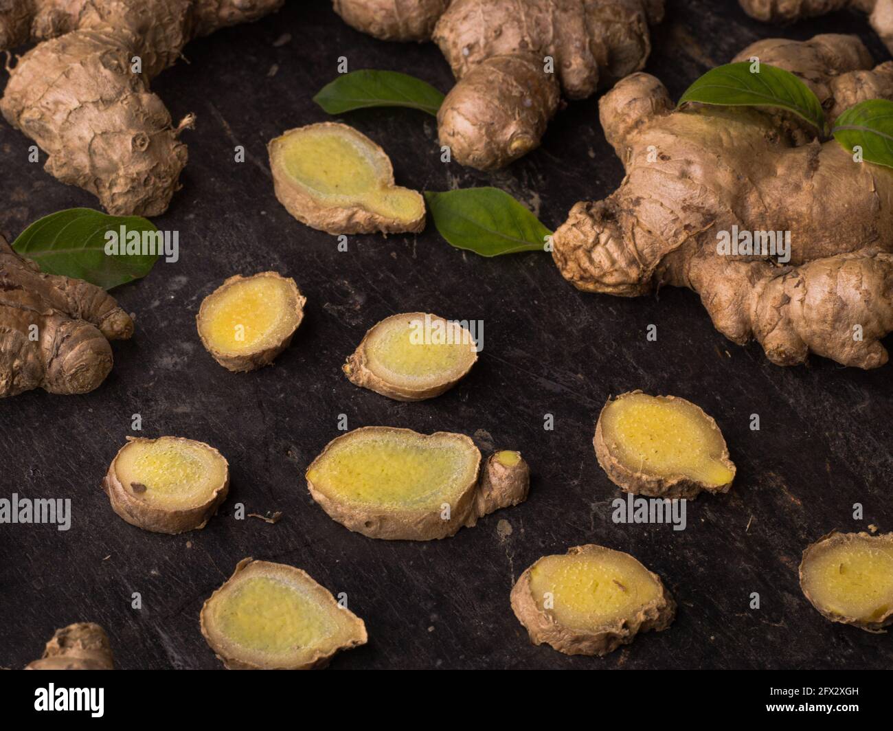 Fresh Ginger on black texture background stock image Stock Photo - Alamy