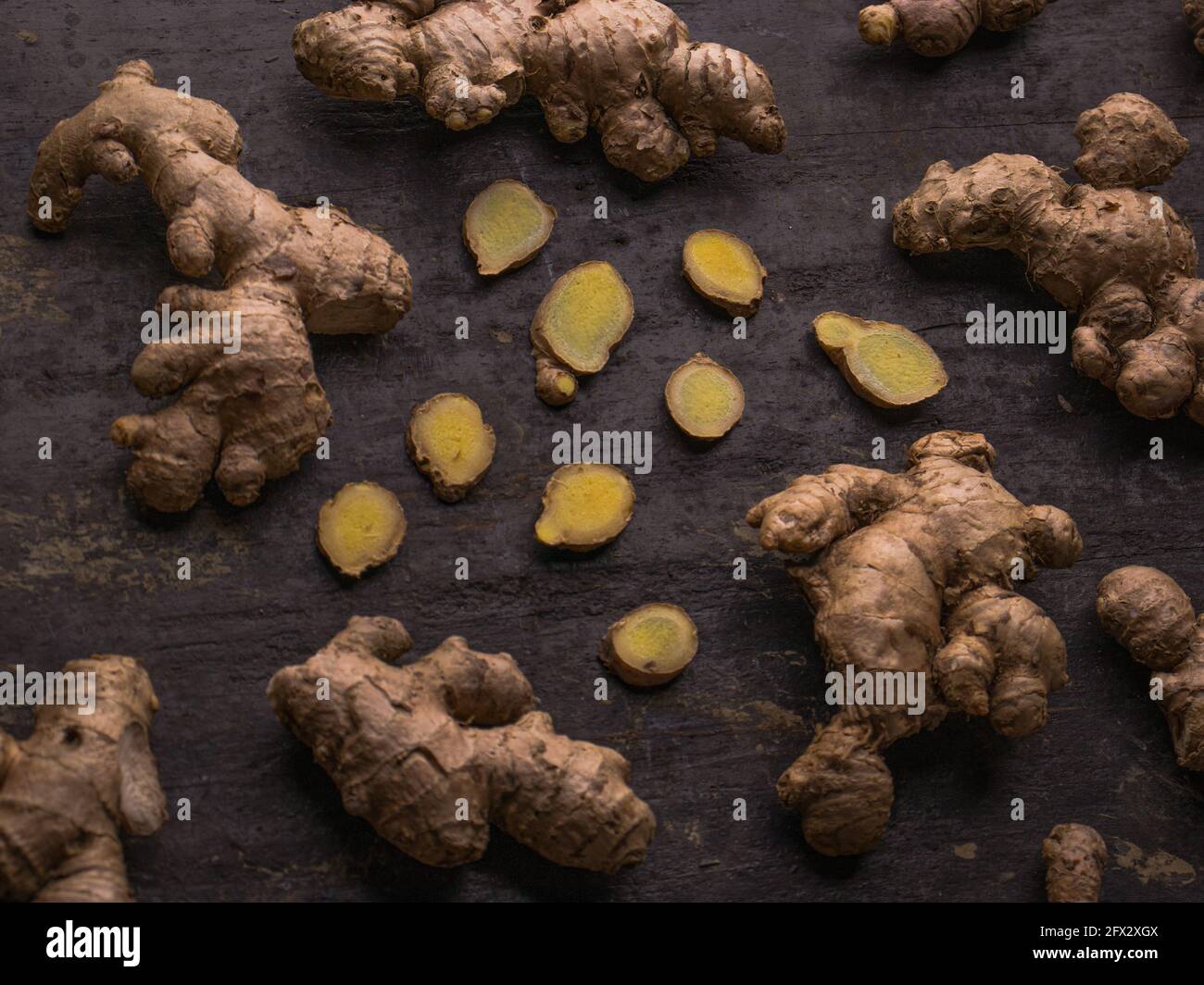 Fresh Ginger on black texture background stock image Stock Photo - Alamy