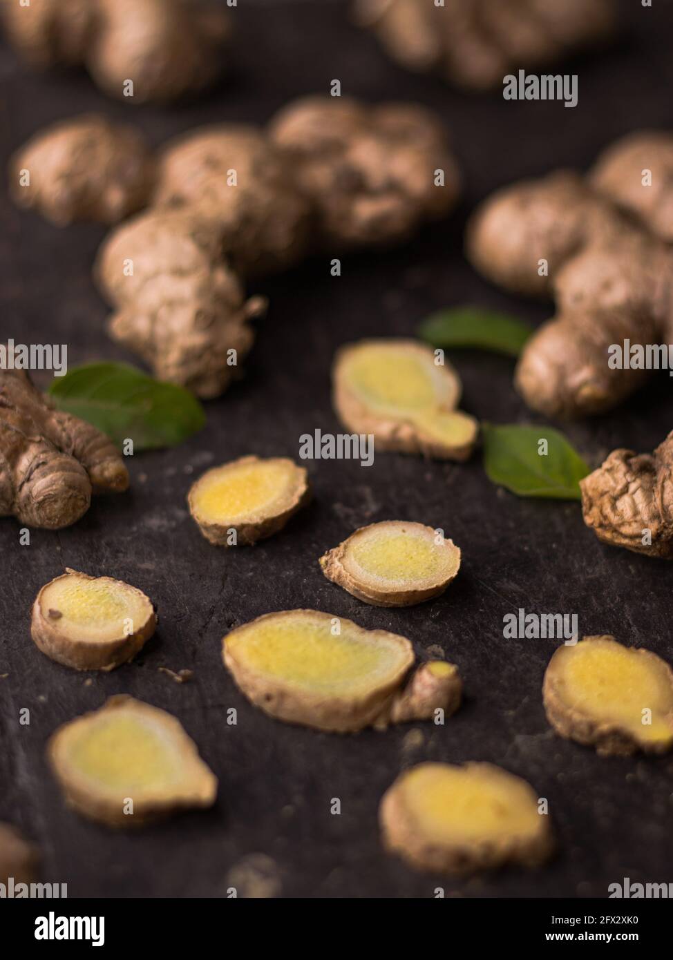 Fresh Ginger on black texture background stock image Stock Photo - Alamy
