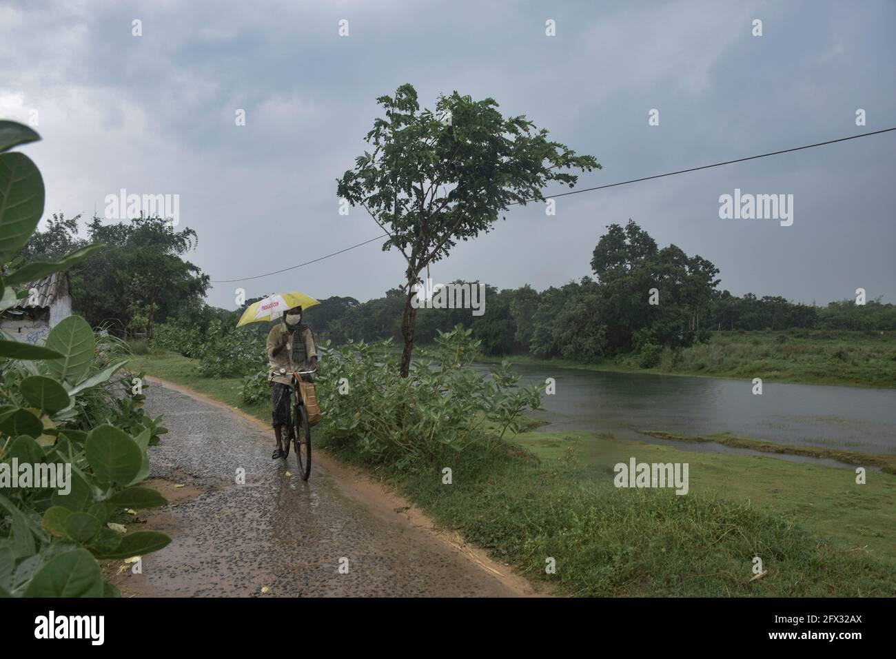 A man seen cycling in rain before the landfall of 'Yaas' cyclone ...