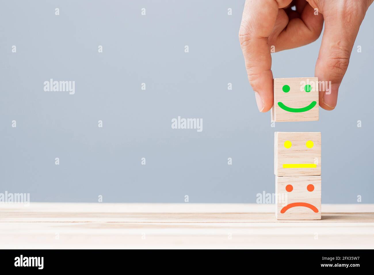 Hand holding smile face symbol on wooden cube blocks. Emotion, Service ...