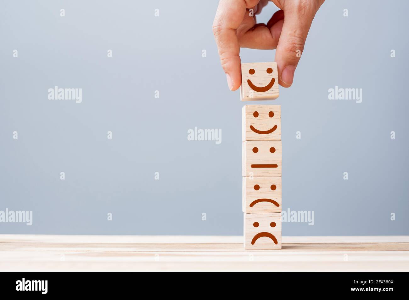 Hand holding smile face symbol on wooden cube blocks. Emotion, Service ...
