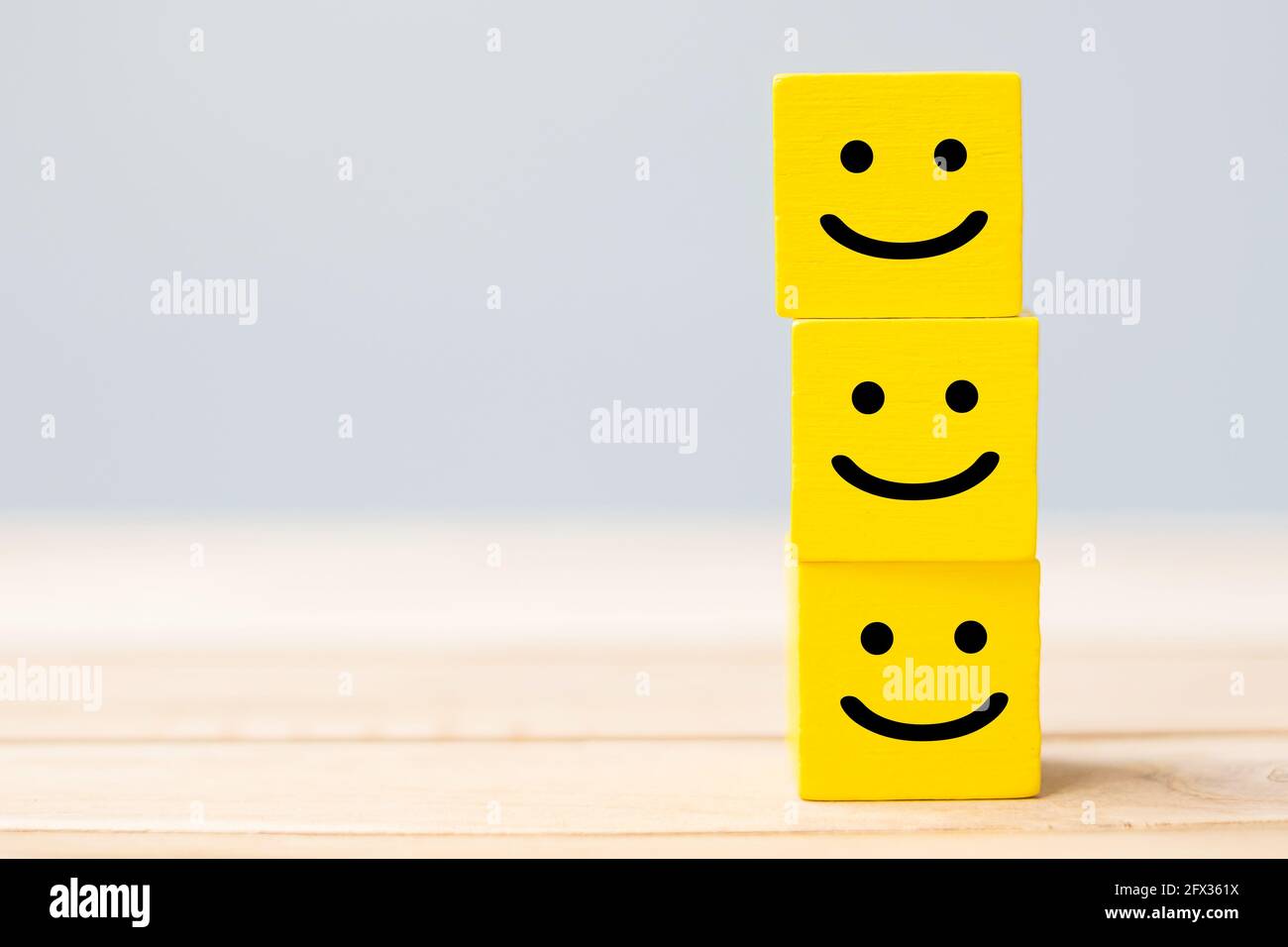 Smile face symbol on yellow wooden cube blocks. Emotion, Service rating ...