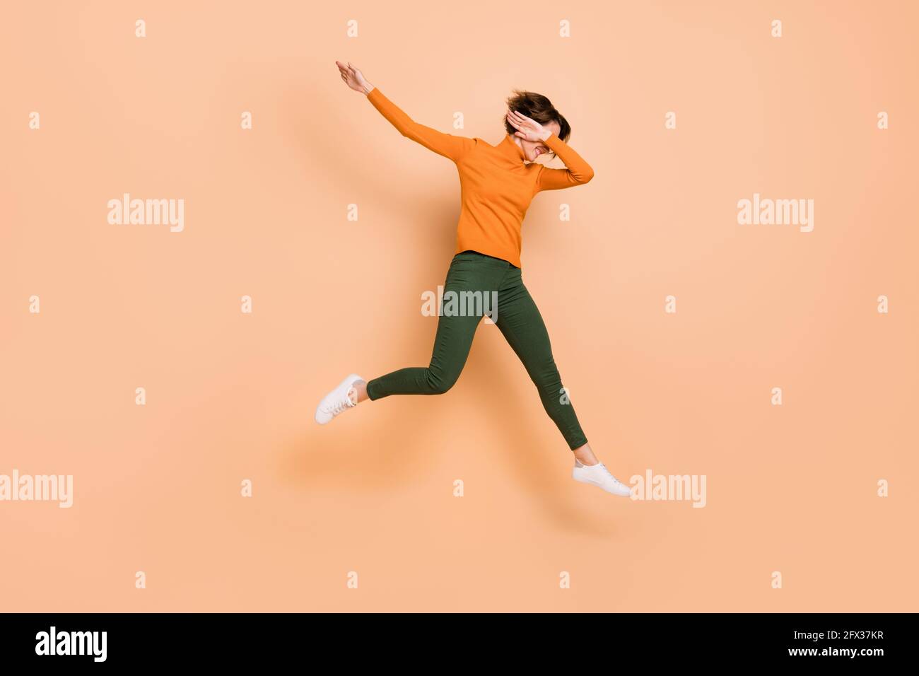 Full length photo of pretty funky young girl orange turtleneck showing ...