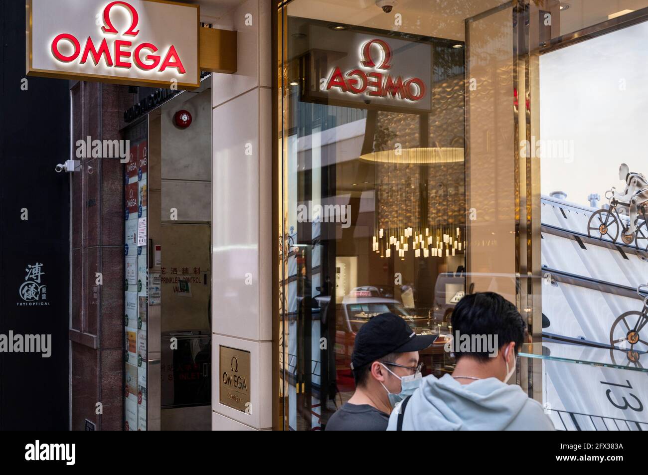 Shoppers are seen window shopping at the Swiss luxury watchmaker Omega ...