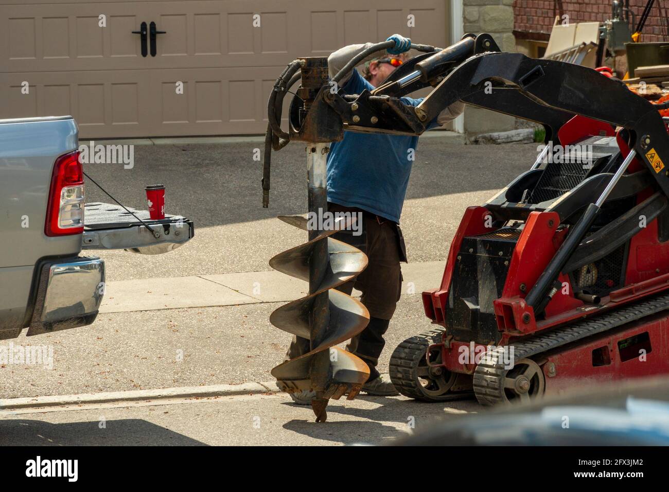 Connecting hydraulics to a large drill for drilling holes in the ground ...