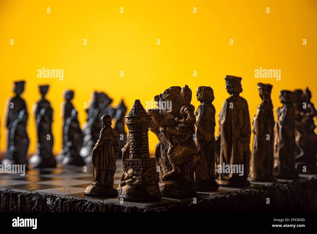 stylized chess pieces on a board with orange background and selective ...