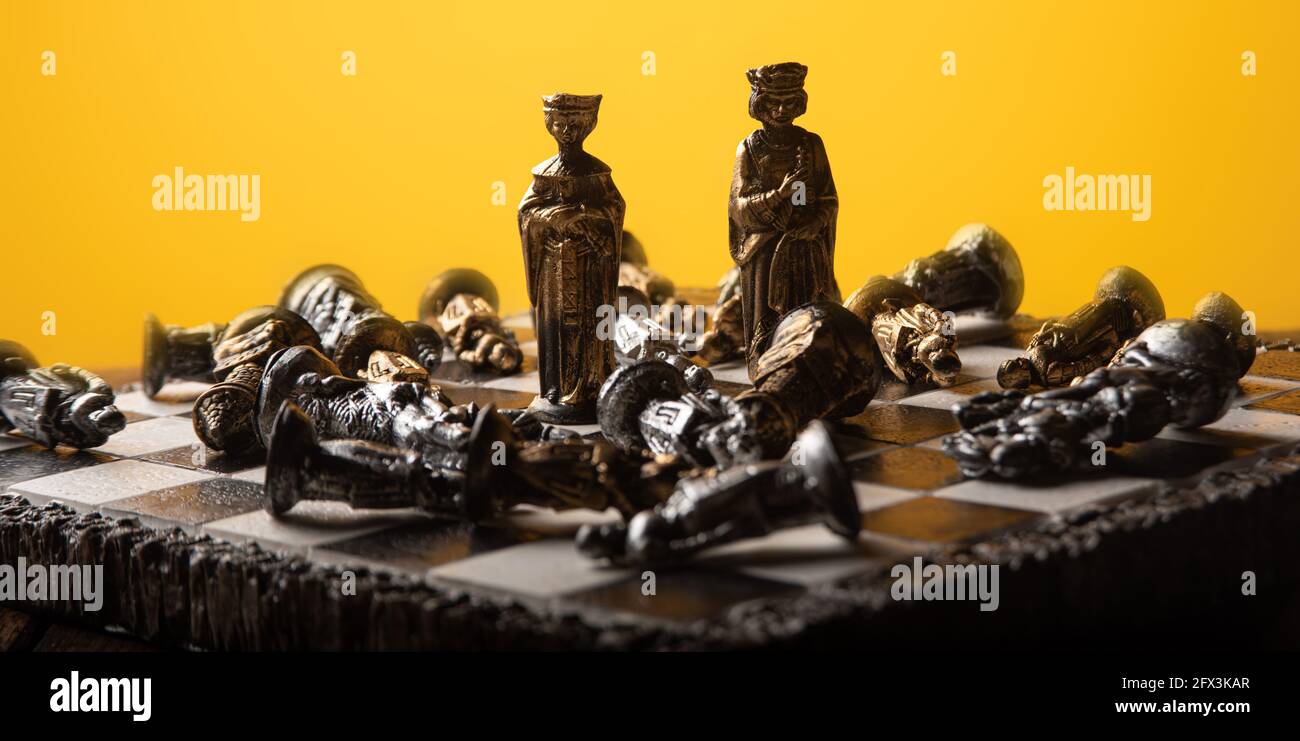 stylized chess pieces on a board with orange background and selective ...