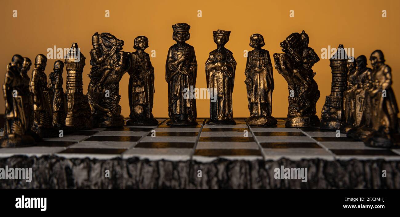 stylized chess pieces on a board with orange background and selective ...