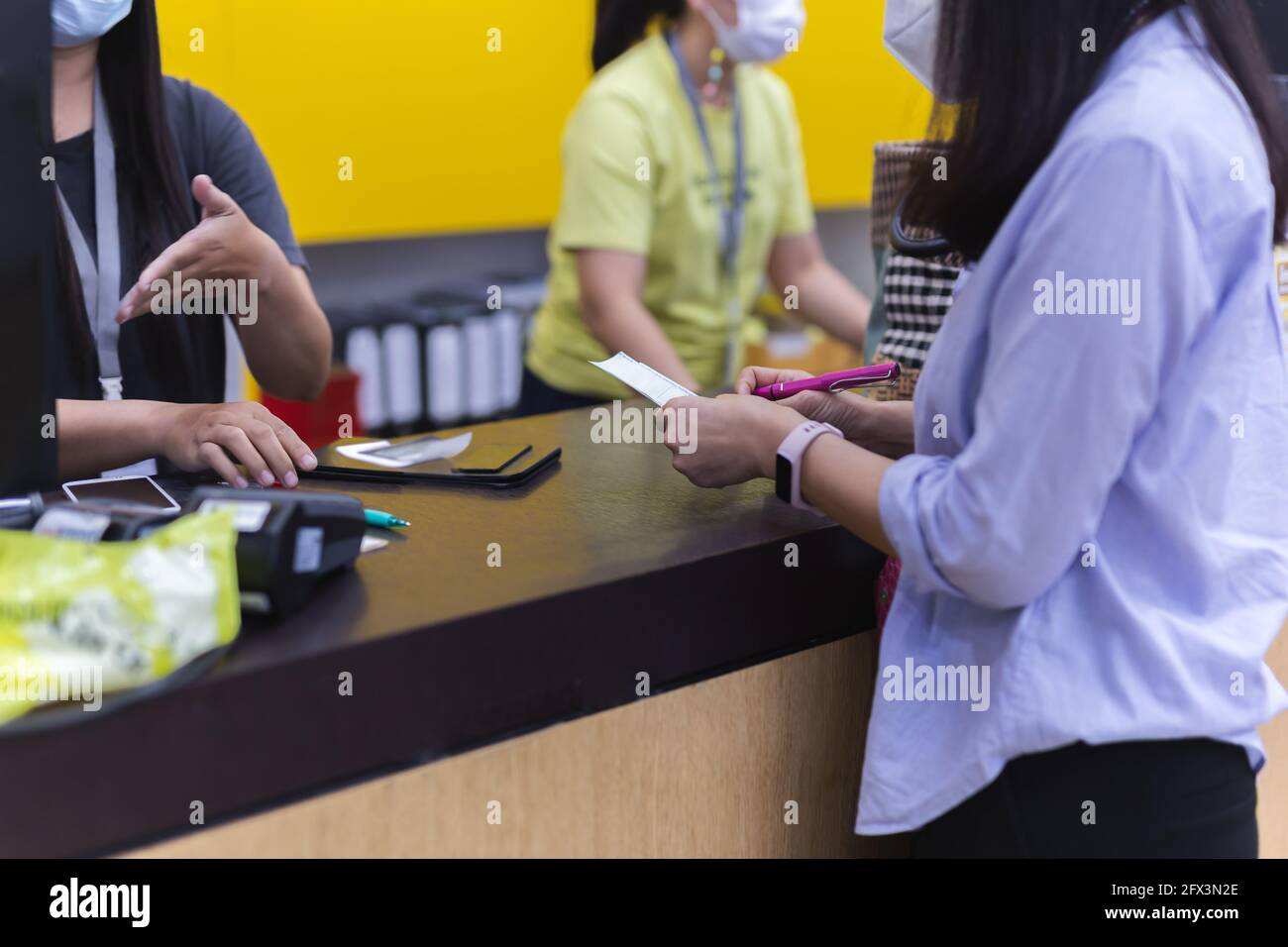 Woman customer holding transaction receipt with credit card at cashier ...