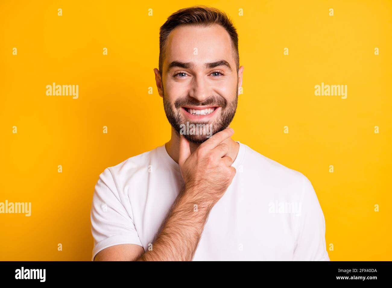 Portrait of optimistic guy hand chin wear white t-shirt isolated on ...