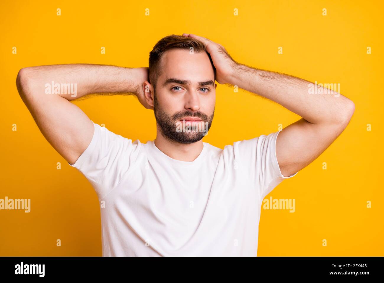 Portrait of attractive well-groomed guy caressing healthy hair isolated ...