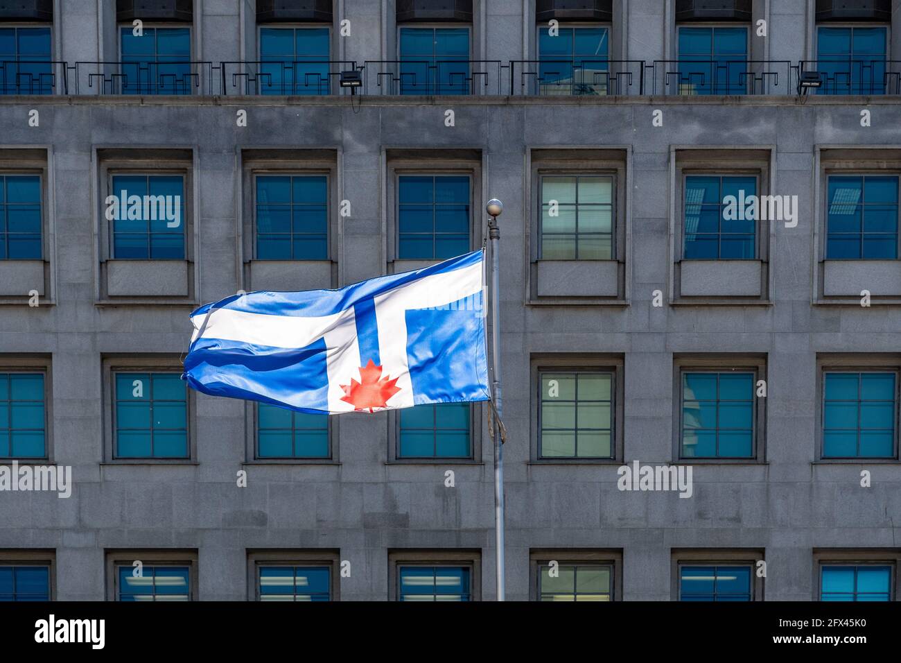 Flag of Toronto city backlit and against a pattern of windows in the ...