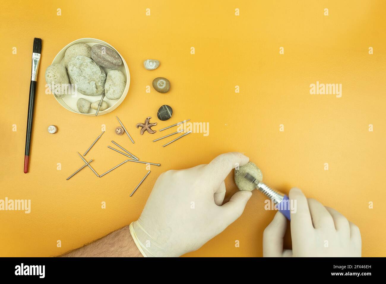 Stone processing with an engraving machine. The man's hands are ...