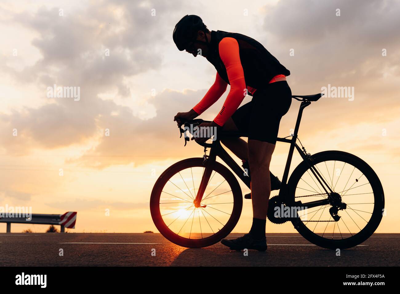 Muscular cyclist standing on road with his bike for racing Stock Photo ...