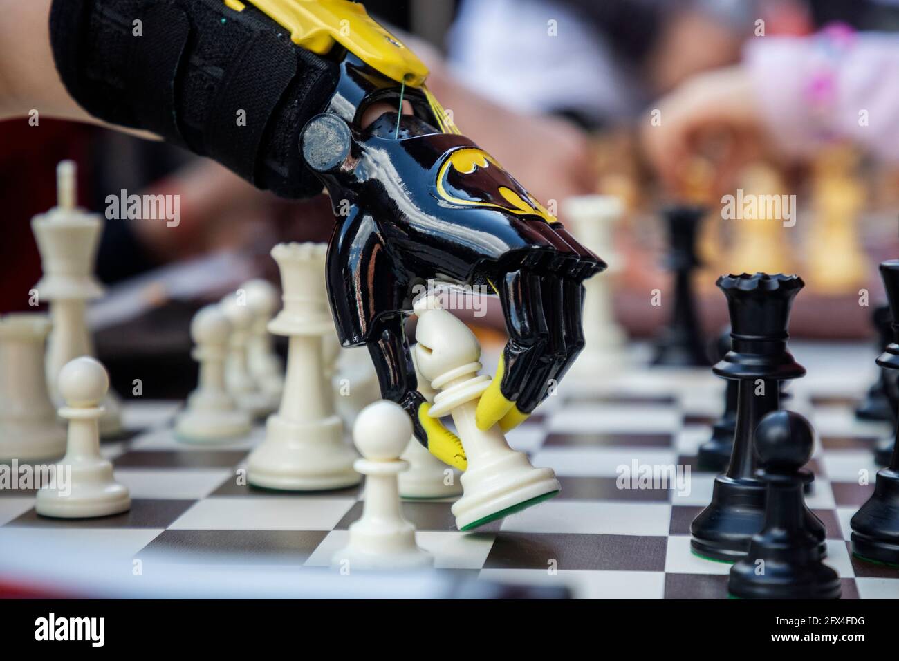 A boy with a bionic prosthetic arm plays chess Stock Photo - Alamy