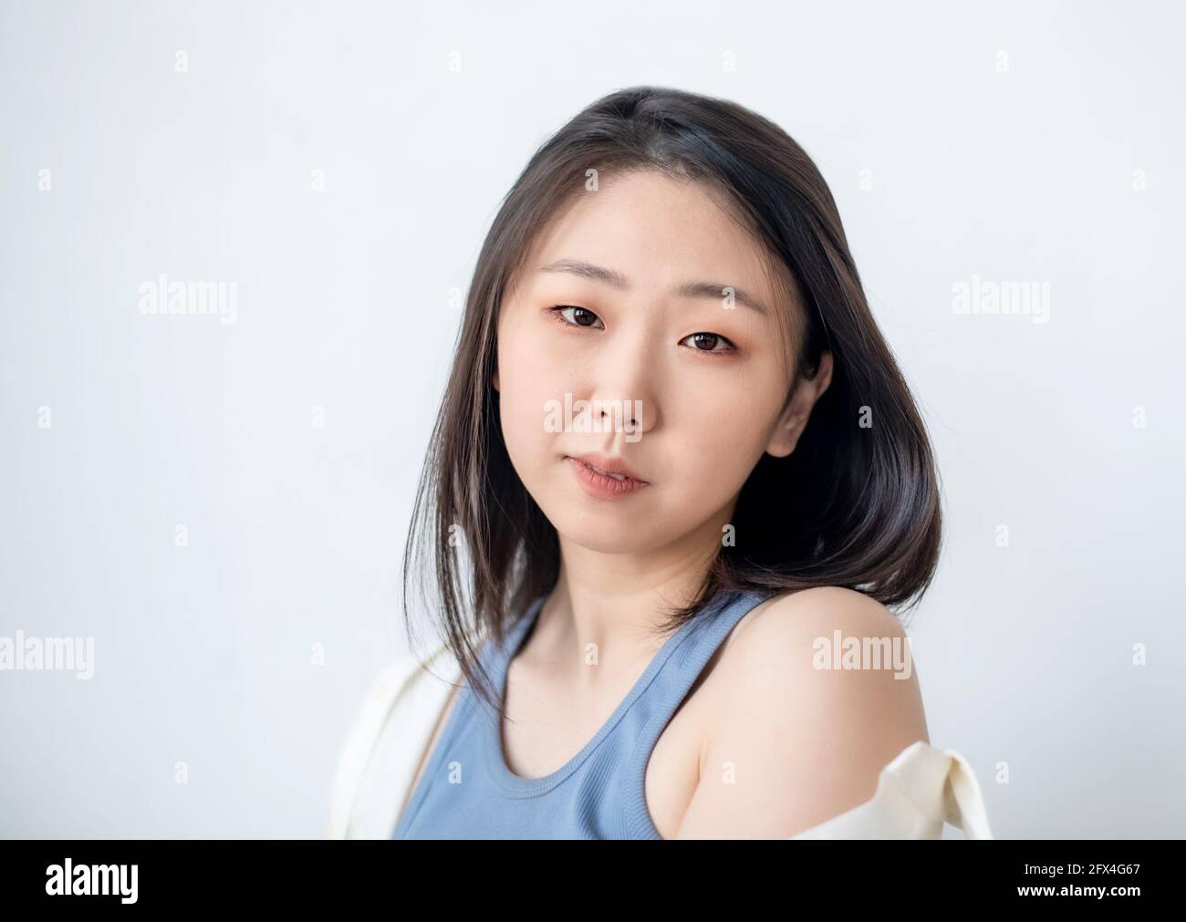 Korean Asian young woman in a stylish light-colored fashion shirt on a ...