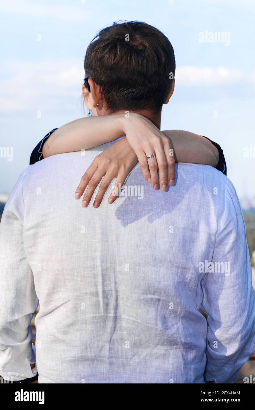 Unrecognizable happy caucasian couple embracing outdoors. Woman's hands ...