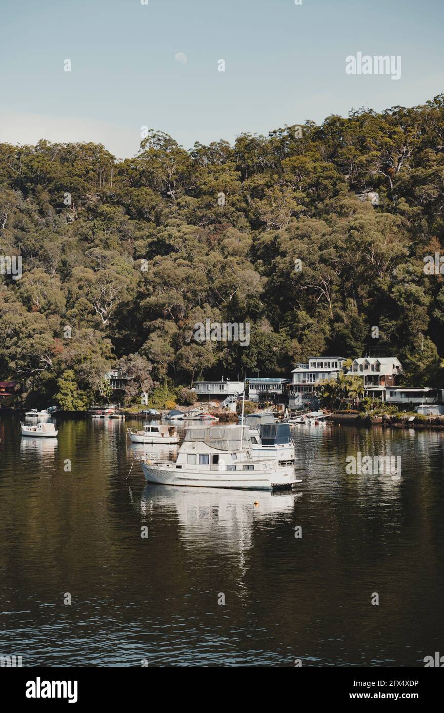 Boats on the water in front of idyllic waterfront houses at Berowra ...