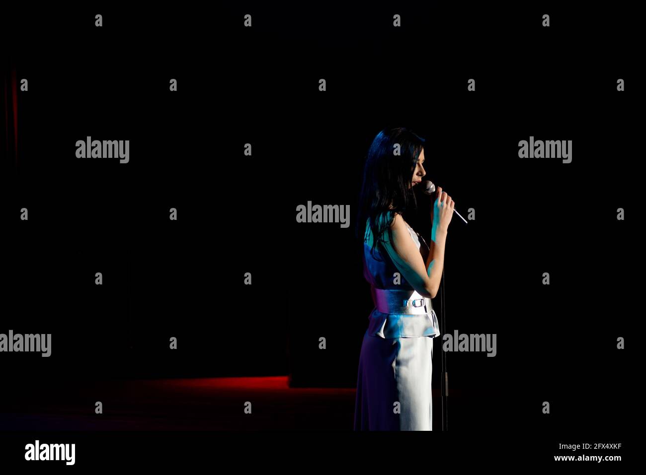 Singer with microphone on the colorful light stage background Stock ...