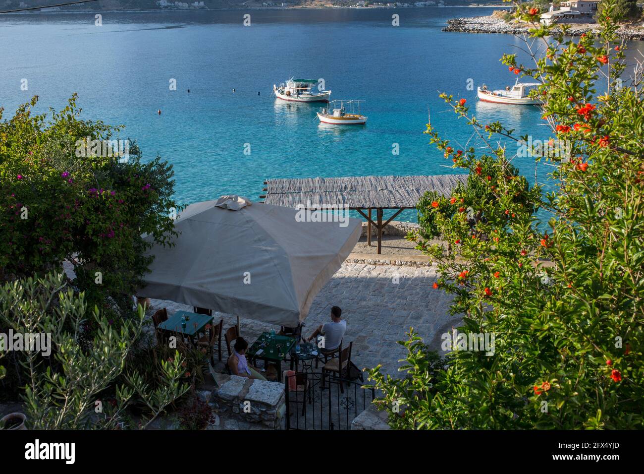 Limeni, Greece. 23rd May, 2021. Tourists sit in a café by the sea in ...