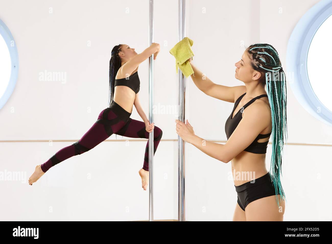 Pole acrobatics workout in training studio gymnast wipes equipment with dry cloth Stock Photo ...