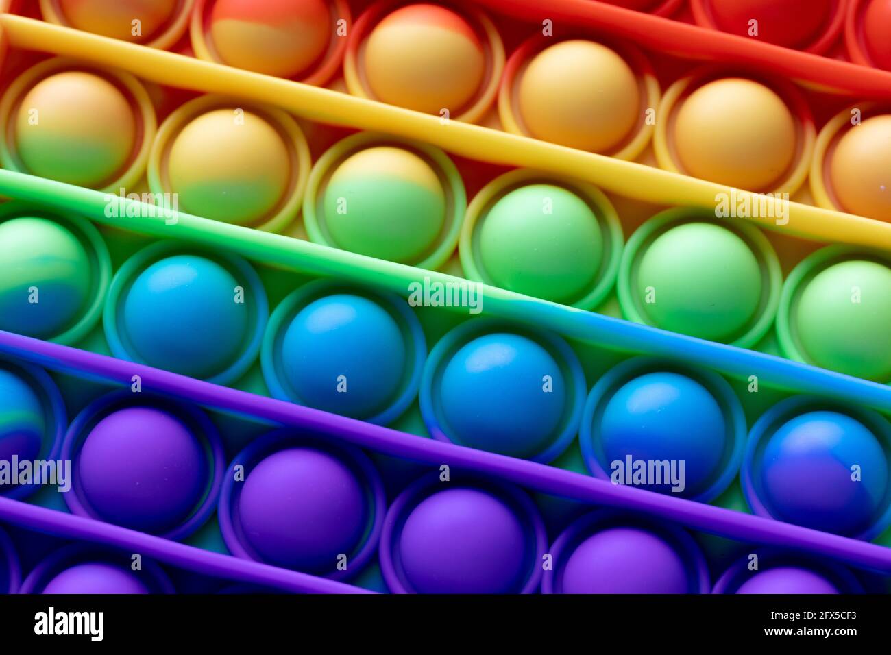 Close-up Pop It texture colorful rainbow background, anti-stress Fidget ...