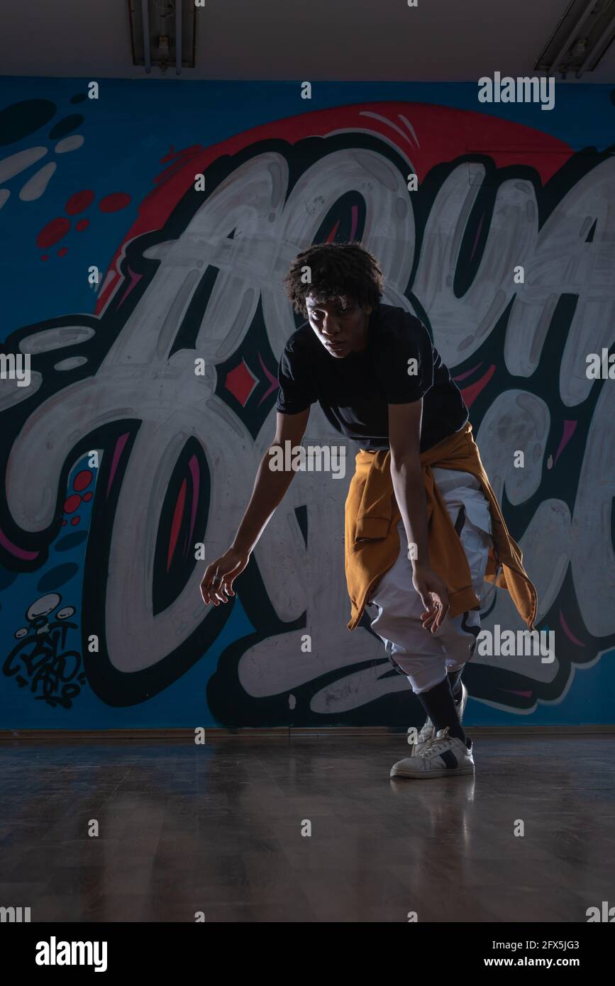 African American hip hop dancer (breakdancer) performing over graffiti ...