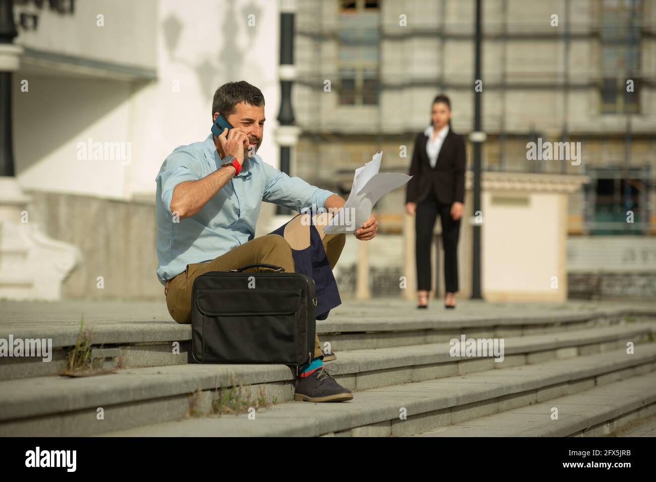 Urban businessman is waiting for his boss on the stairs Stock Photo - Alamy