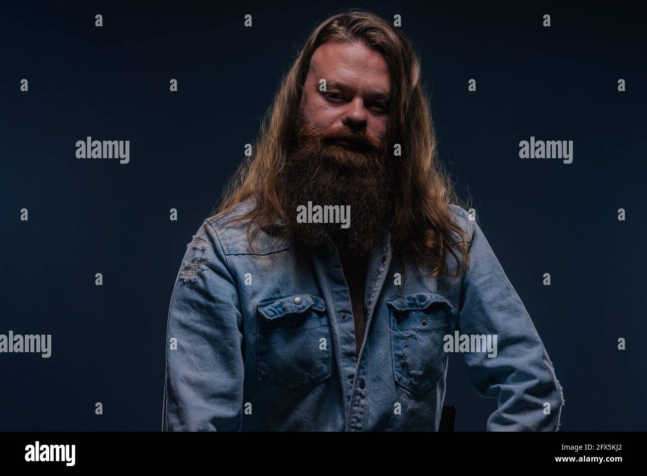 Close up portrait of handsome manly guy with beard posing in studio on ...