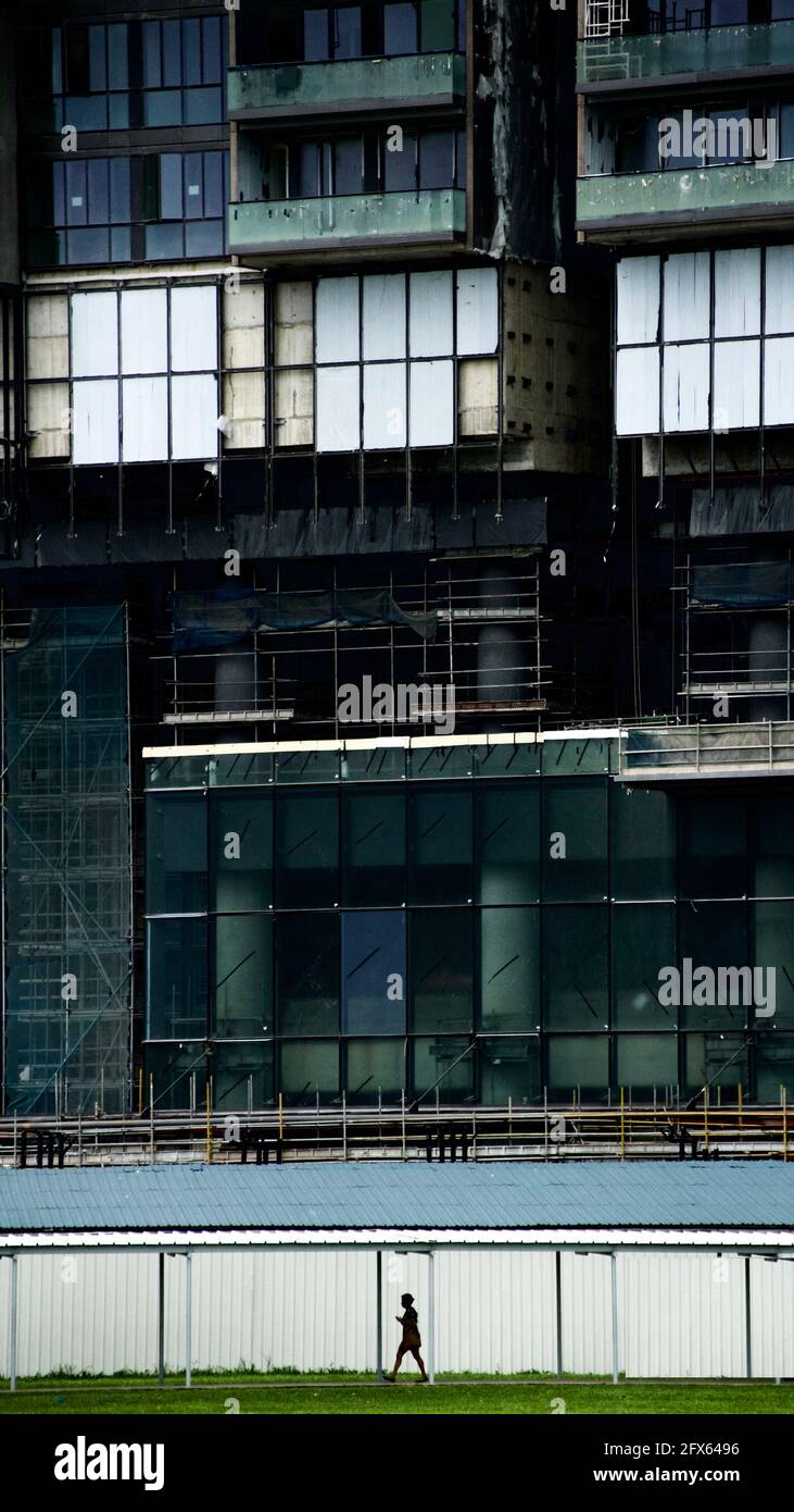 Lady walking alone under huge constructed building in Singapore Stock ...