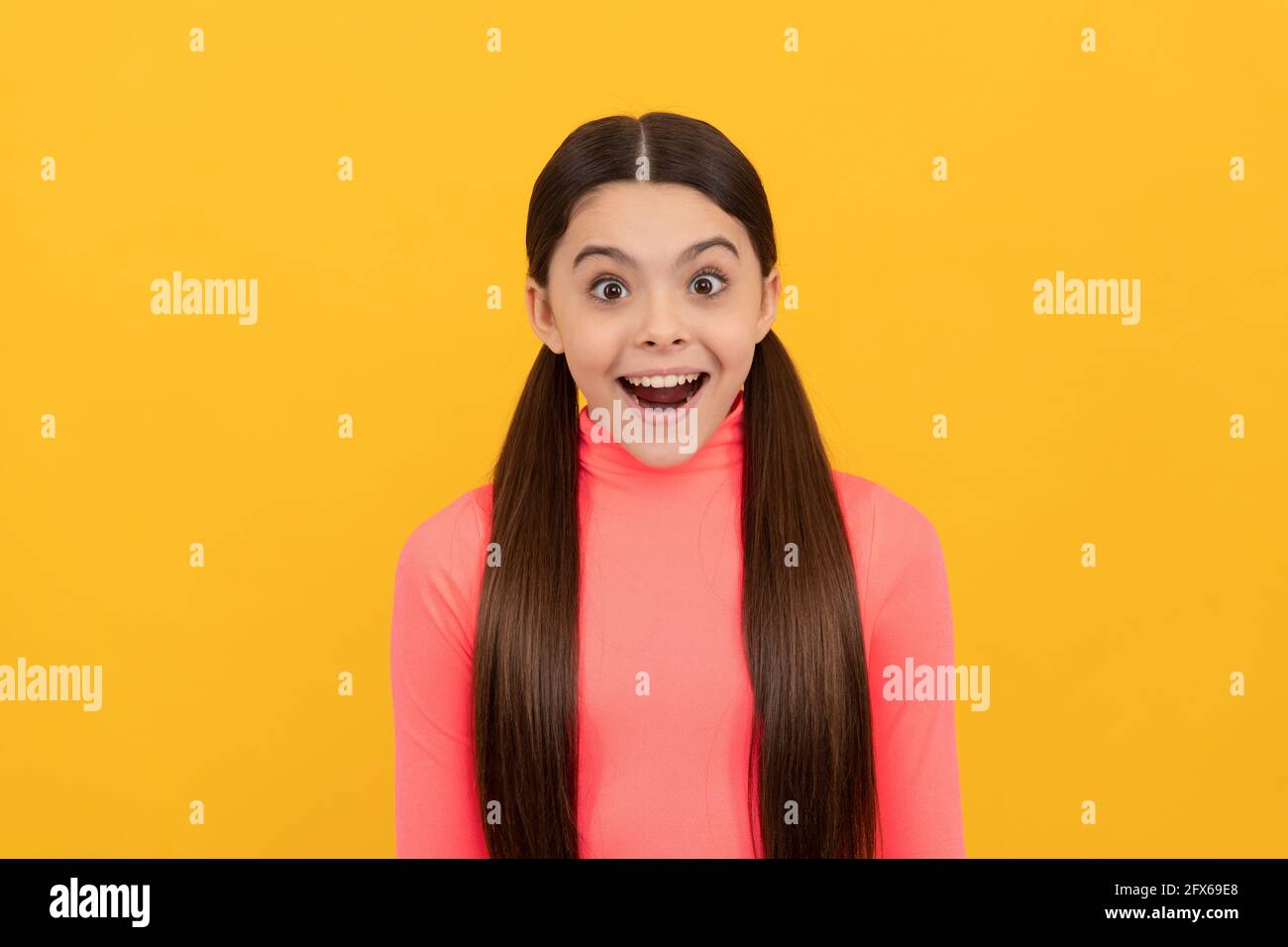 amazed child with long hair on yellow background, surprise Stock Photo ...