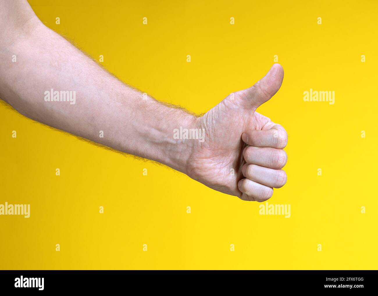 Man's hand with thumb up isolated on yellow background. Showing like ...