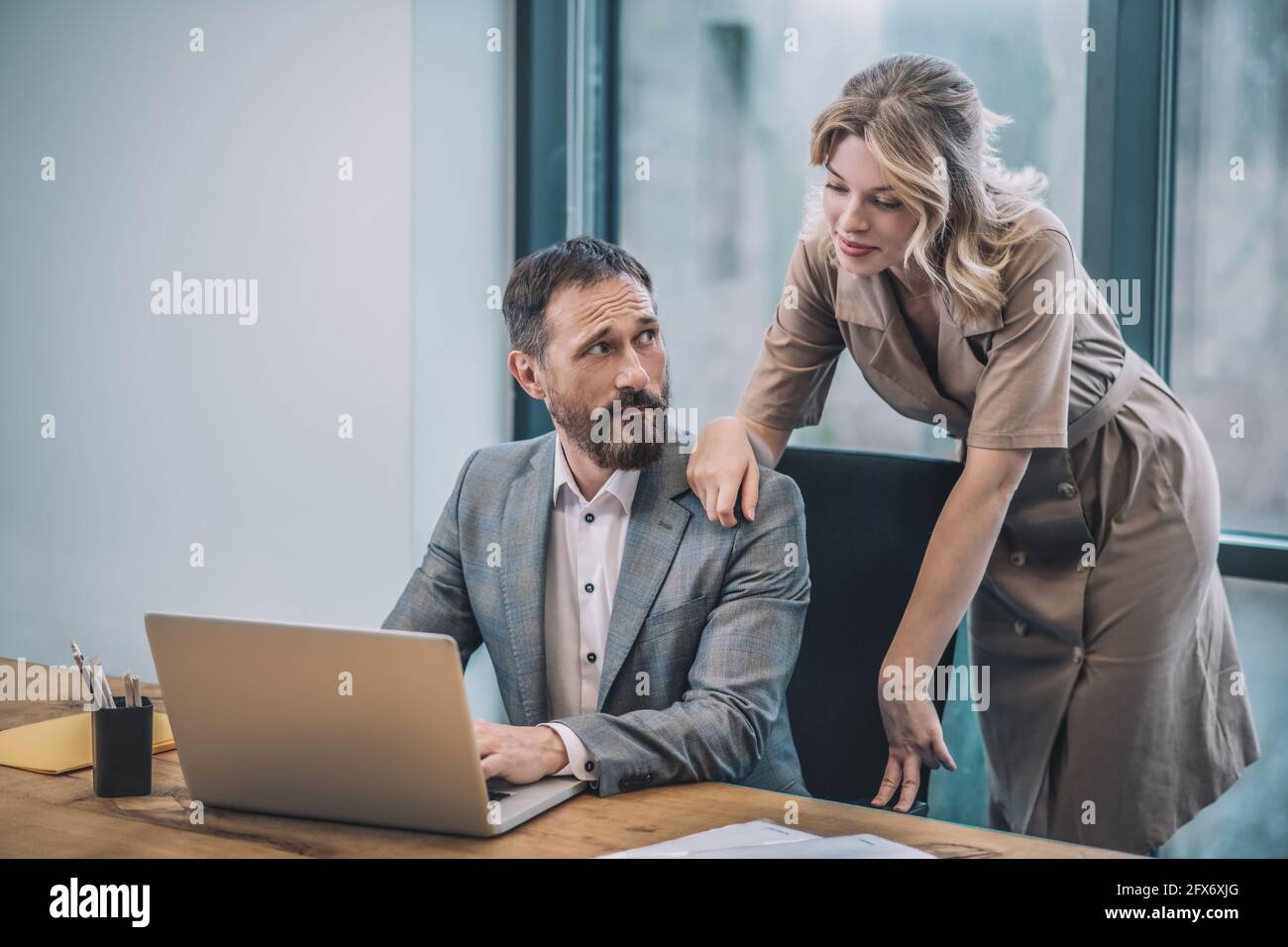 Man behind laptop woman touching his shoulder Stock Photo - Alamy