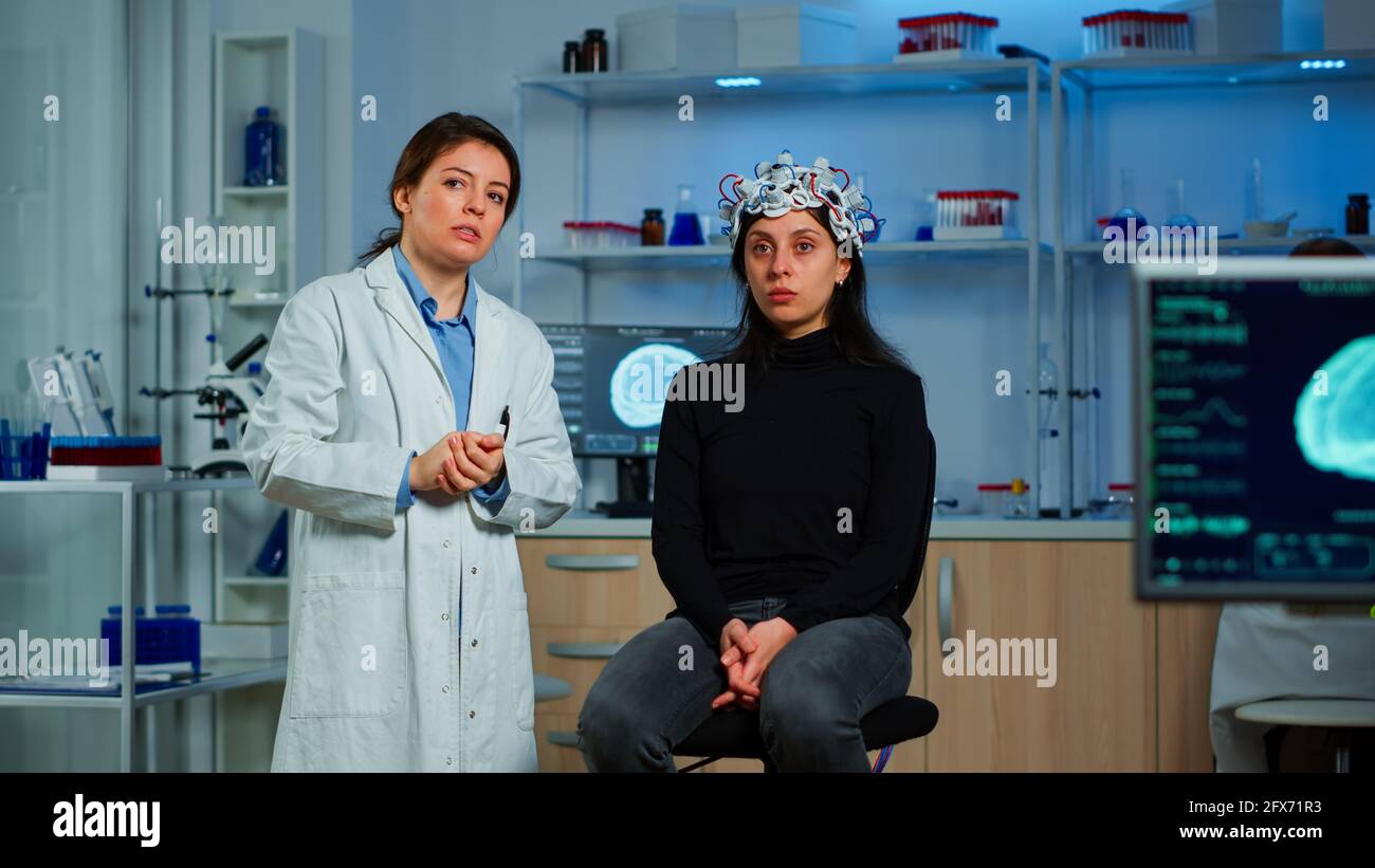 Researcher and patient with eeg headset looking at virtual display with ...
