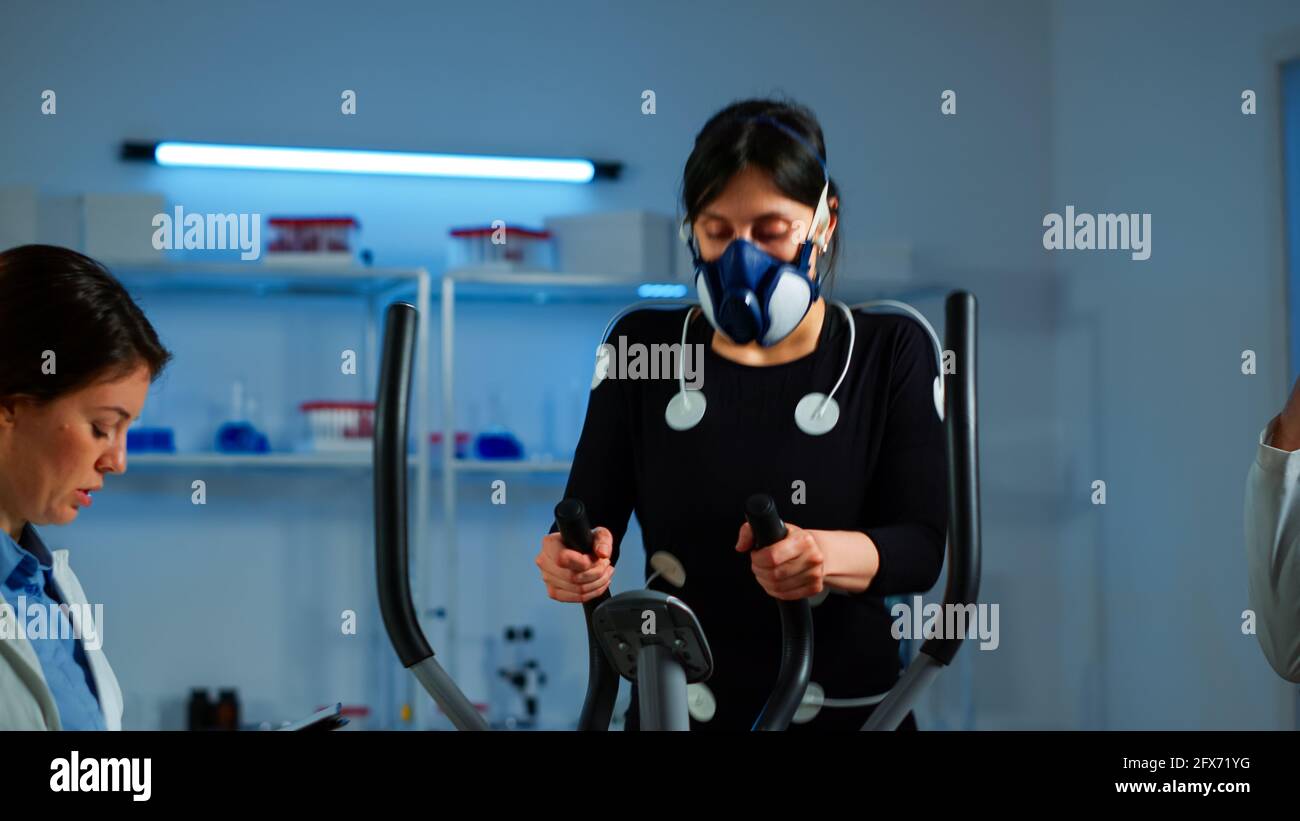 Team of doctor researchers monitoring endurance of woman performance ...