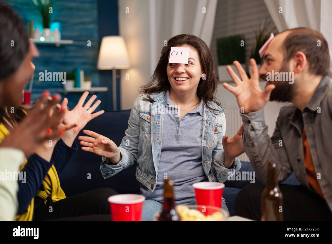 Mixed race friends socializing during entertainment party while playing ...