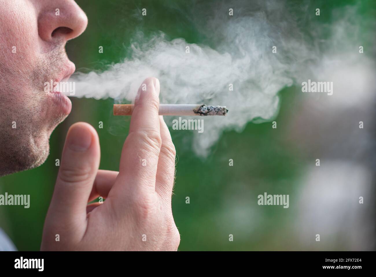 Cropped close up man smoking cigarette outdoors shot Stock Photo - Alamy