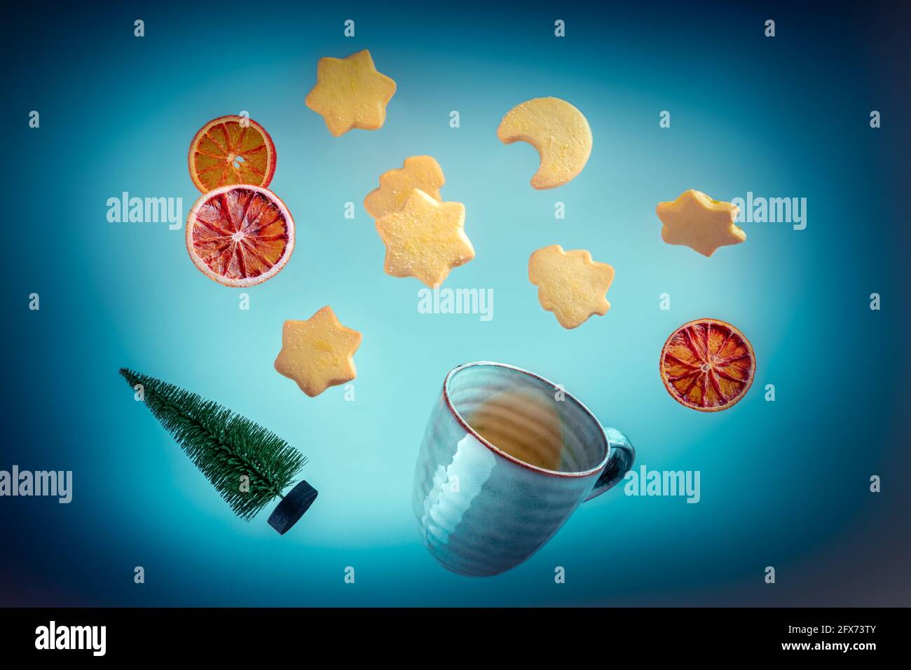 Flying butter cookies, tea, and a Christmas tree on a dark blue ...