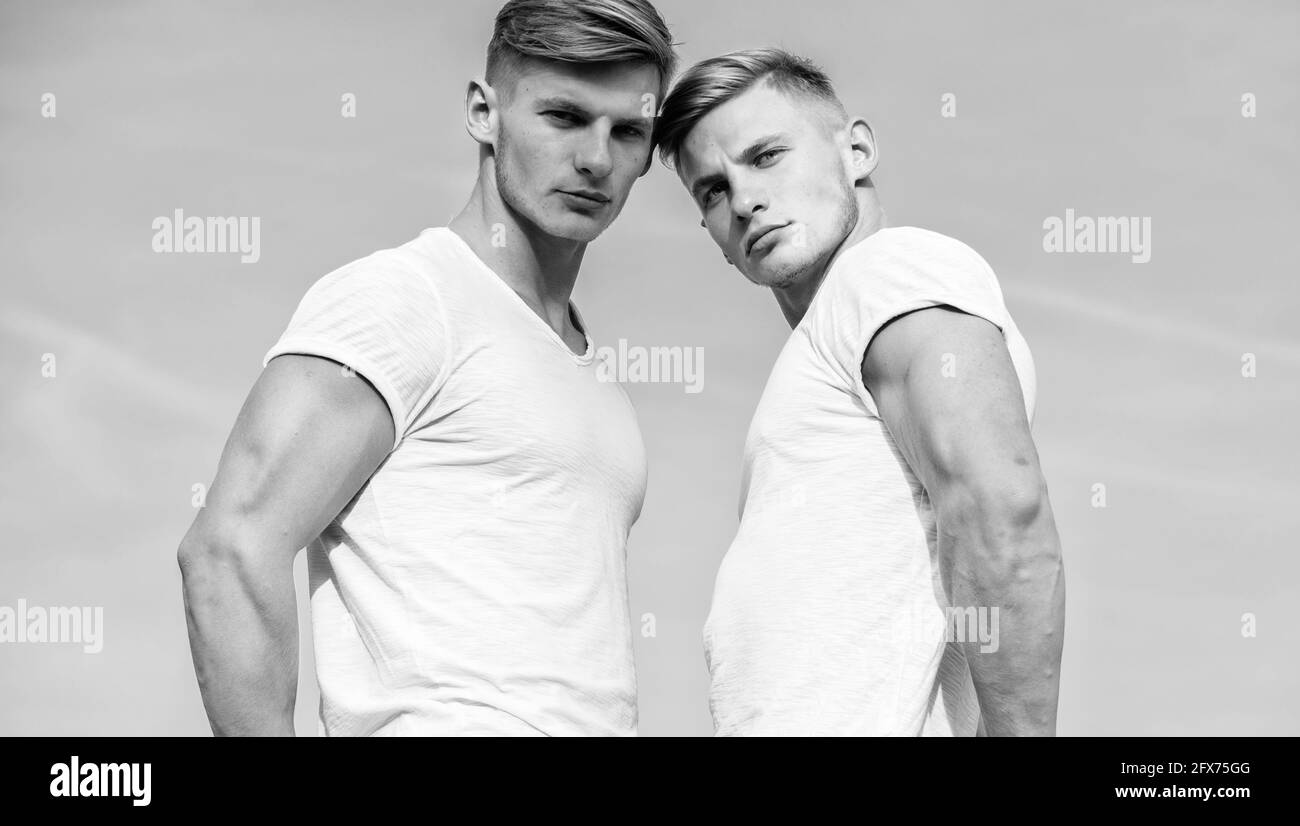Men twins muscular brothers sky background. Handsome strong twins. Men ...