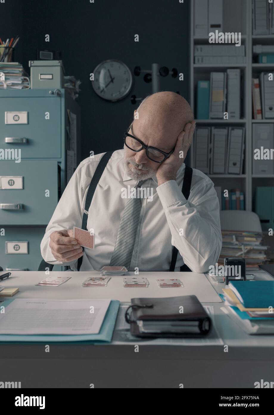 Lazy unproductive employee sitting at office desk and playing cards ...