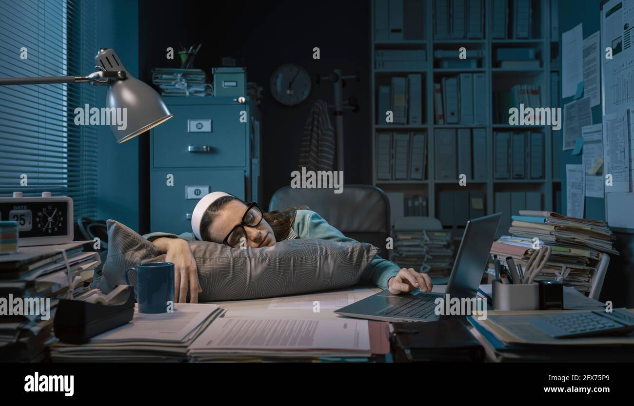 Exhausted young office worker sleeping at her desk, job burnout and ...