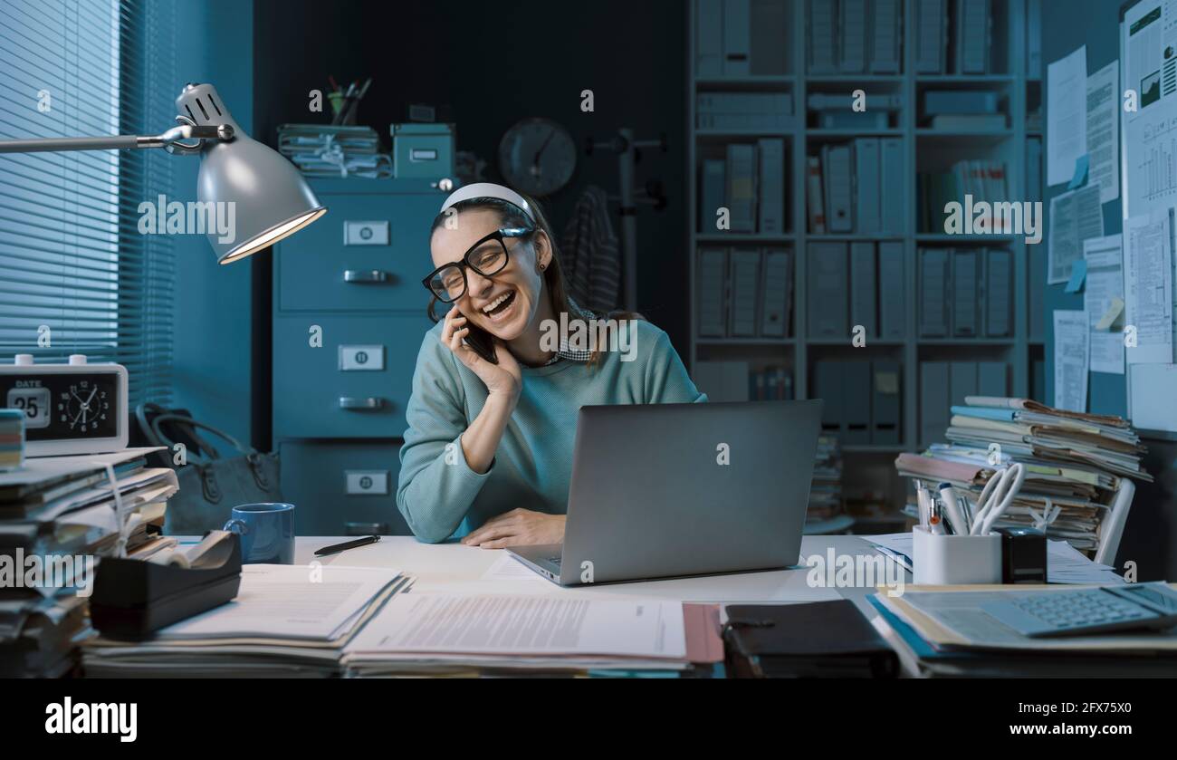 Lazy office worker sitting at desk and talking on the phone with her ...