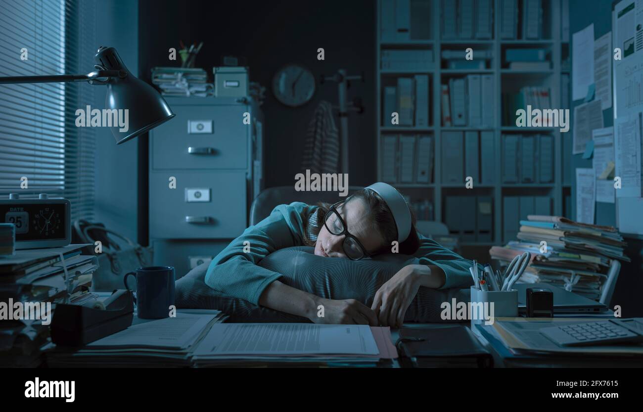 Exhausted young office worker sleeping at her desk, job burnout and ...