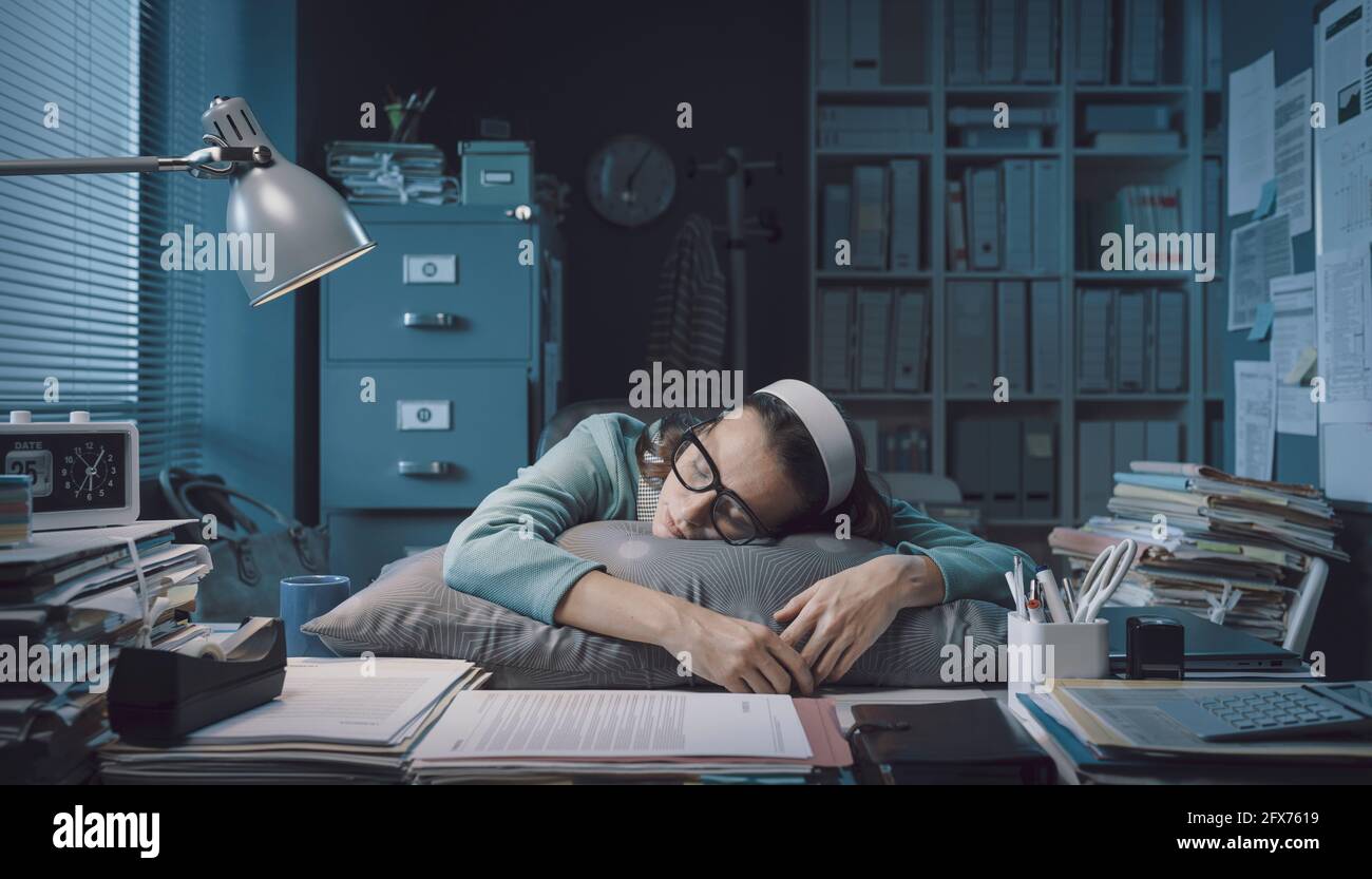 Exhausted young office worker sleeping at her desk, job burnout and ...
