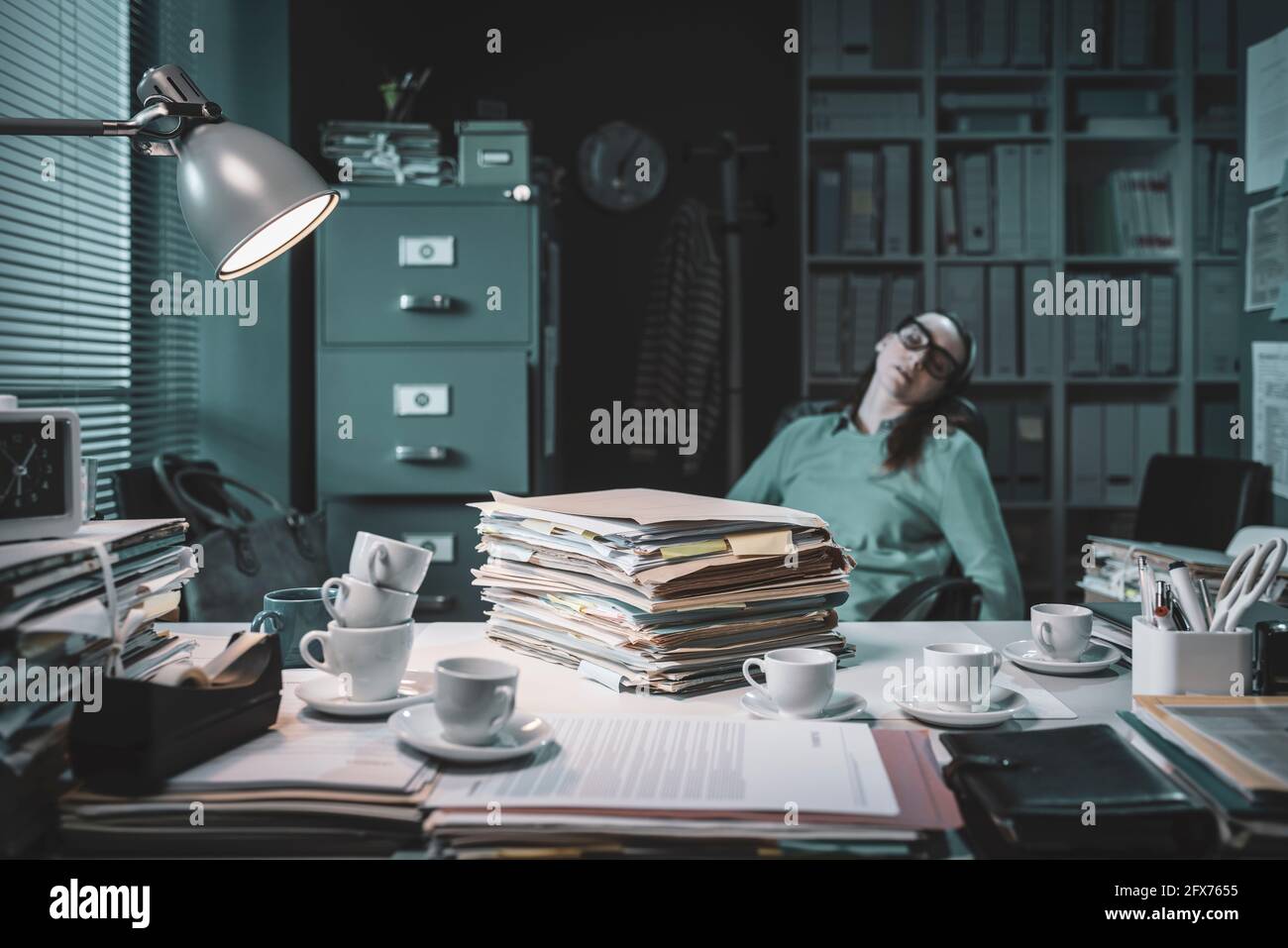 Exhausted office worker falling asleep in the office late at night ...