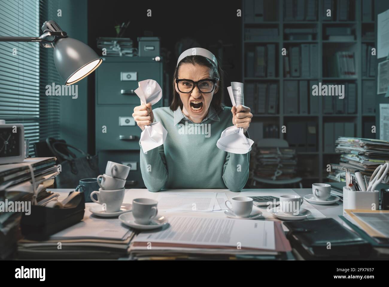 Stressed angry employee working late at night, she is shouting and ...